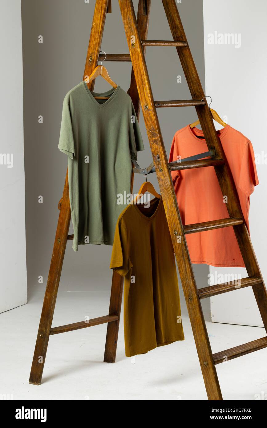 Tshirts displayed on ladder and copy space on white background Stock ...