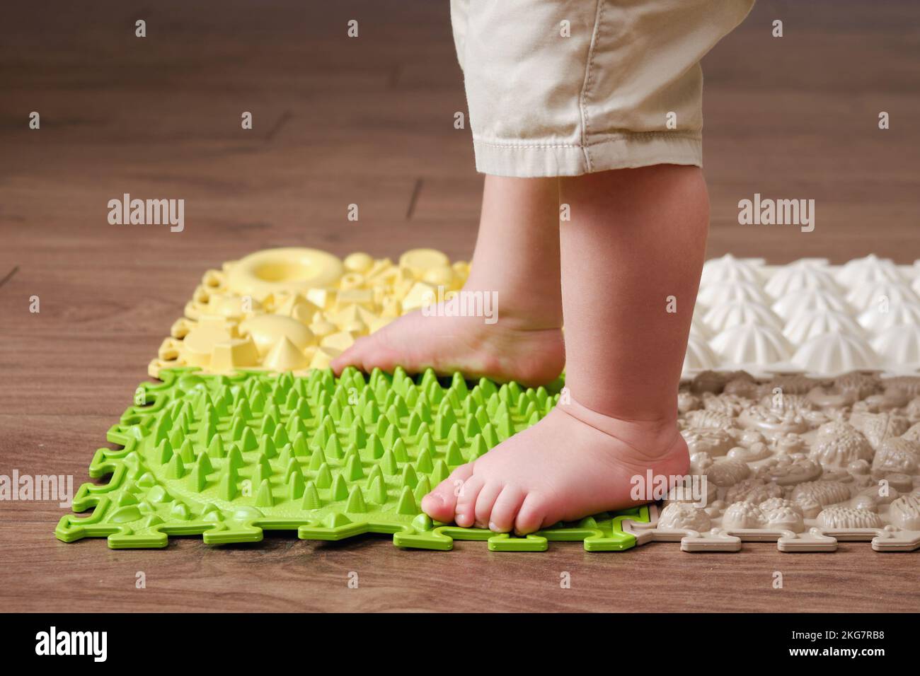 Baby toddler foots close-up on a medical orthopedic mat. Child legs ...