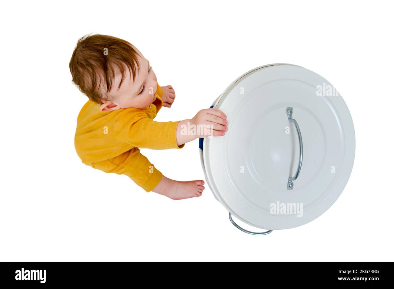 Toddler baby boy opens a trash can with household waste, isolated on a ...