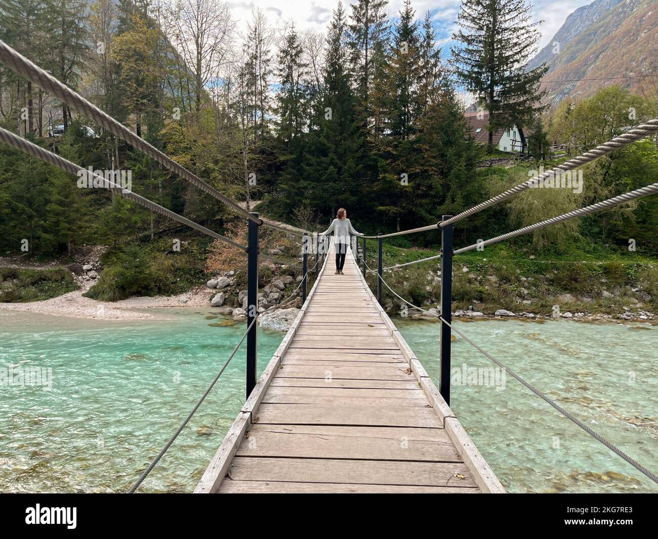 woman looking at the river walking on a wooden bridge in scandinavian ...