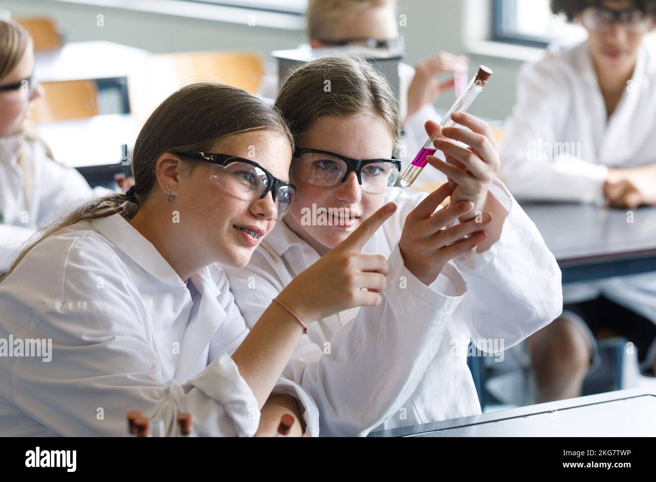 Students looking at react tubes in a chemistry classroom in a secondary ...