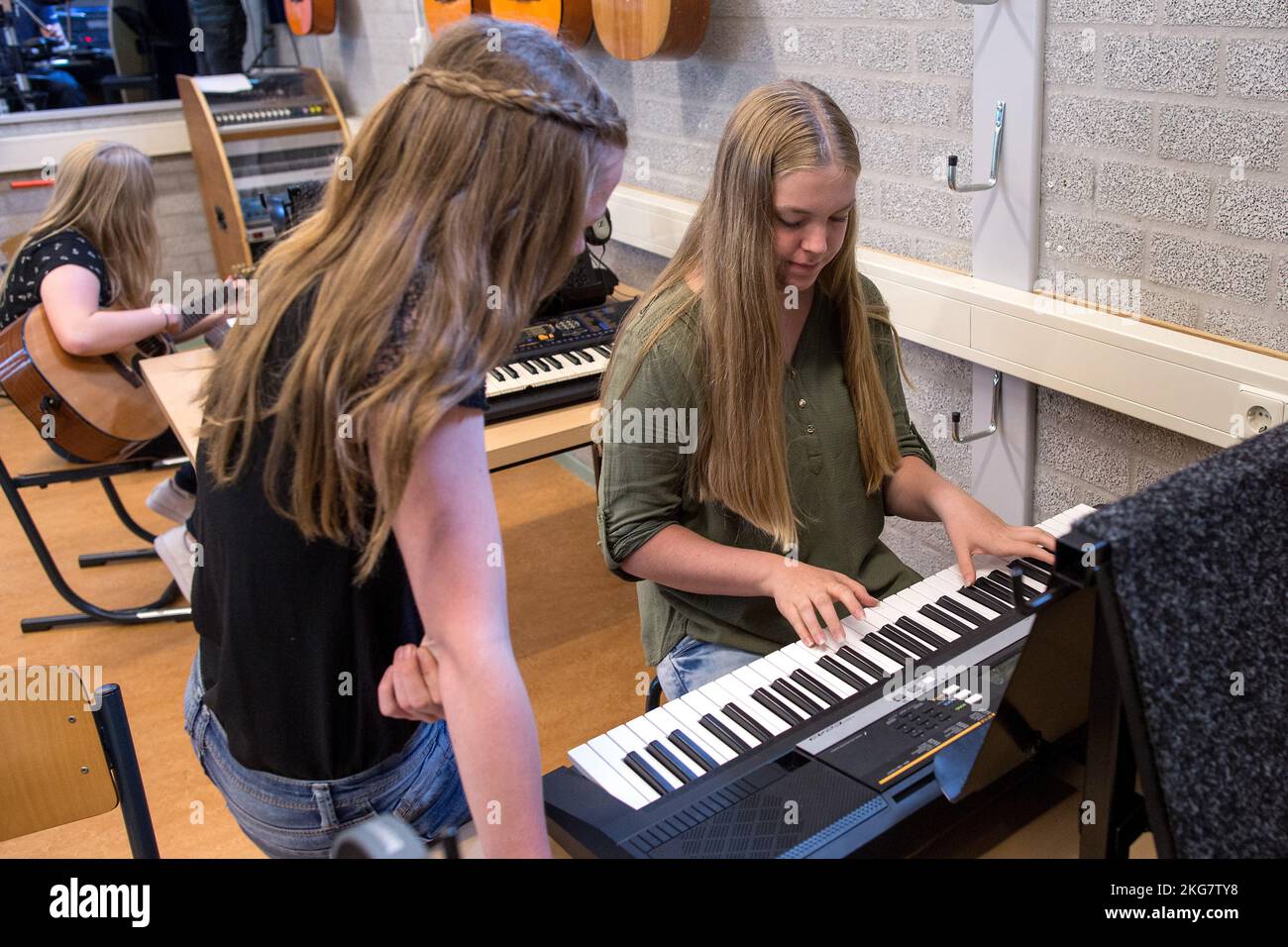 student on a secondary school play on the piano during music lesson ...