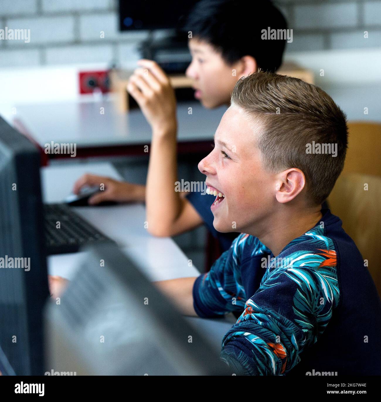 Students on a secondary school works with computer in a classroom ...