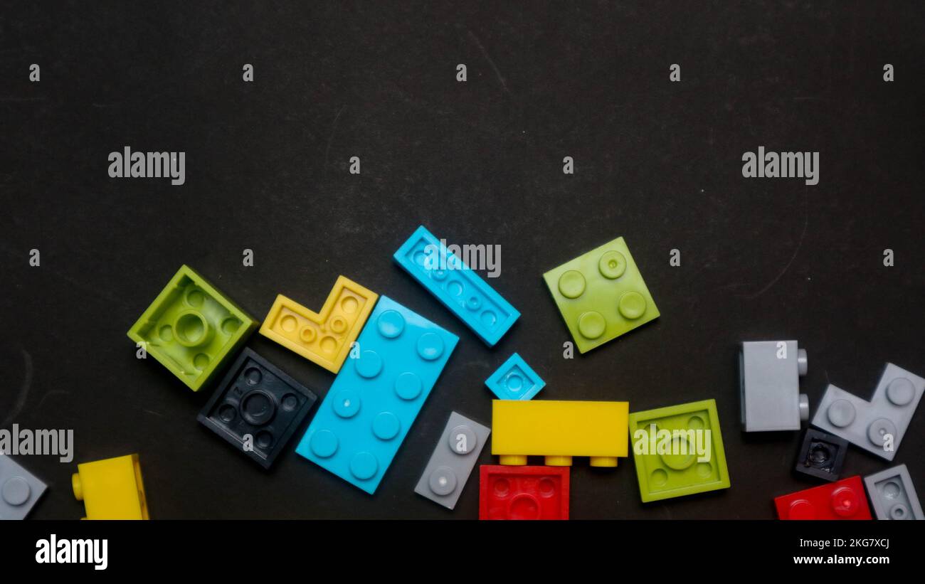 Plastic toy blocks on black background Stock Photo - Alamy