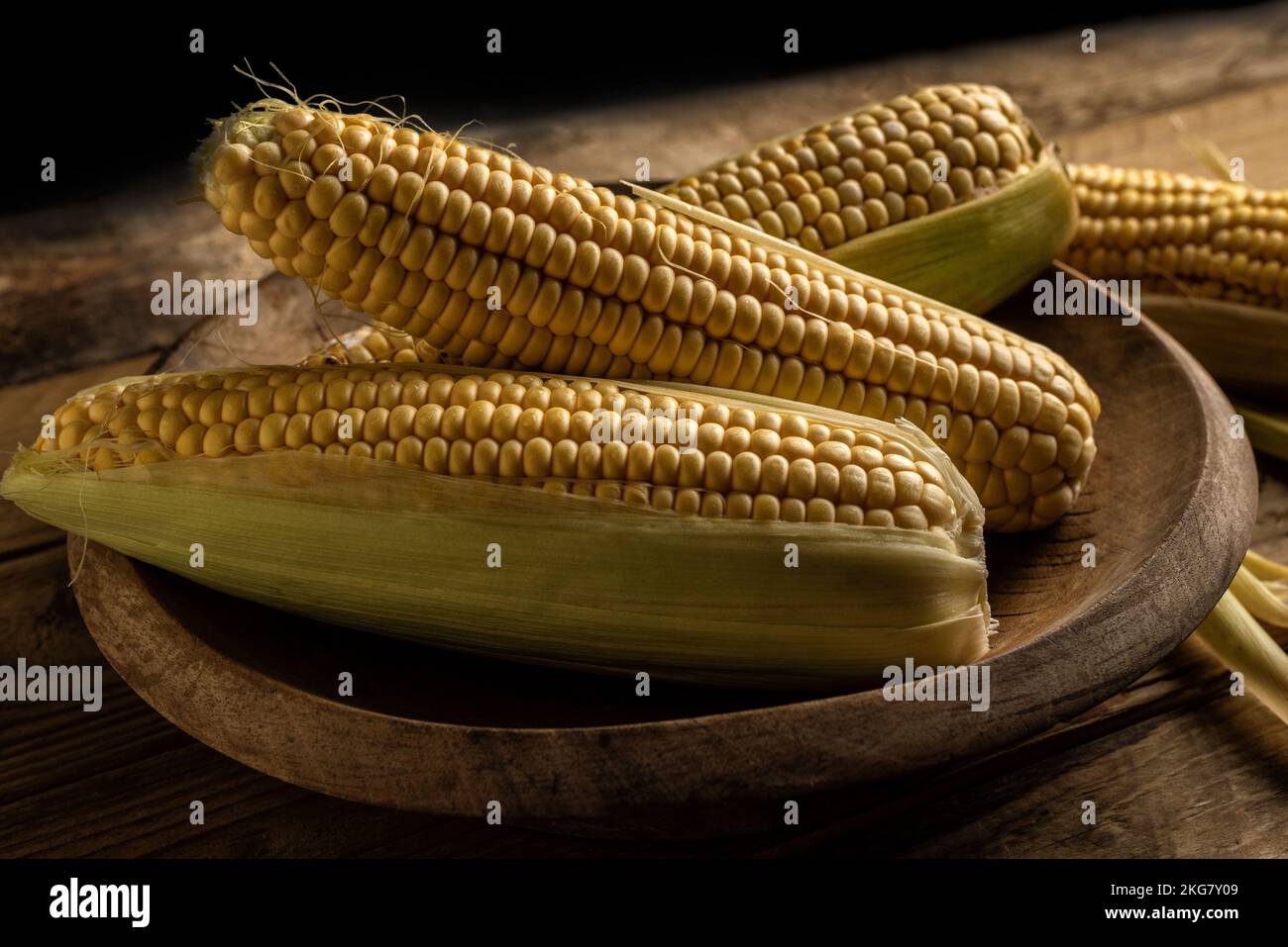 Corn cobs Zea mays on a rustic wooden plate Stock Photo - Alamy