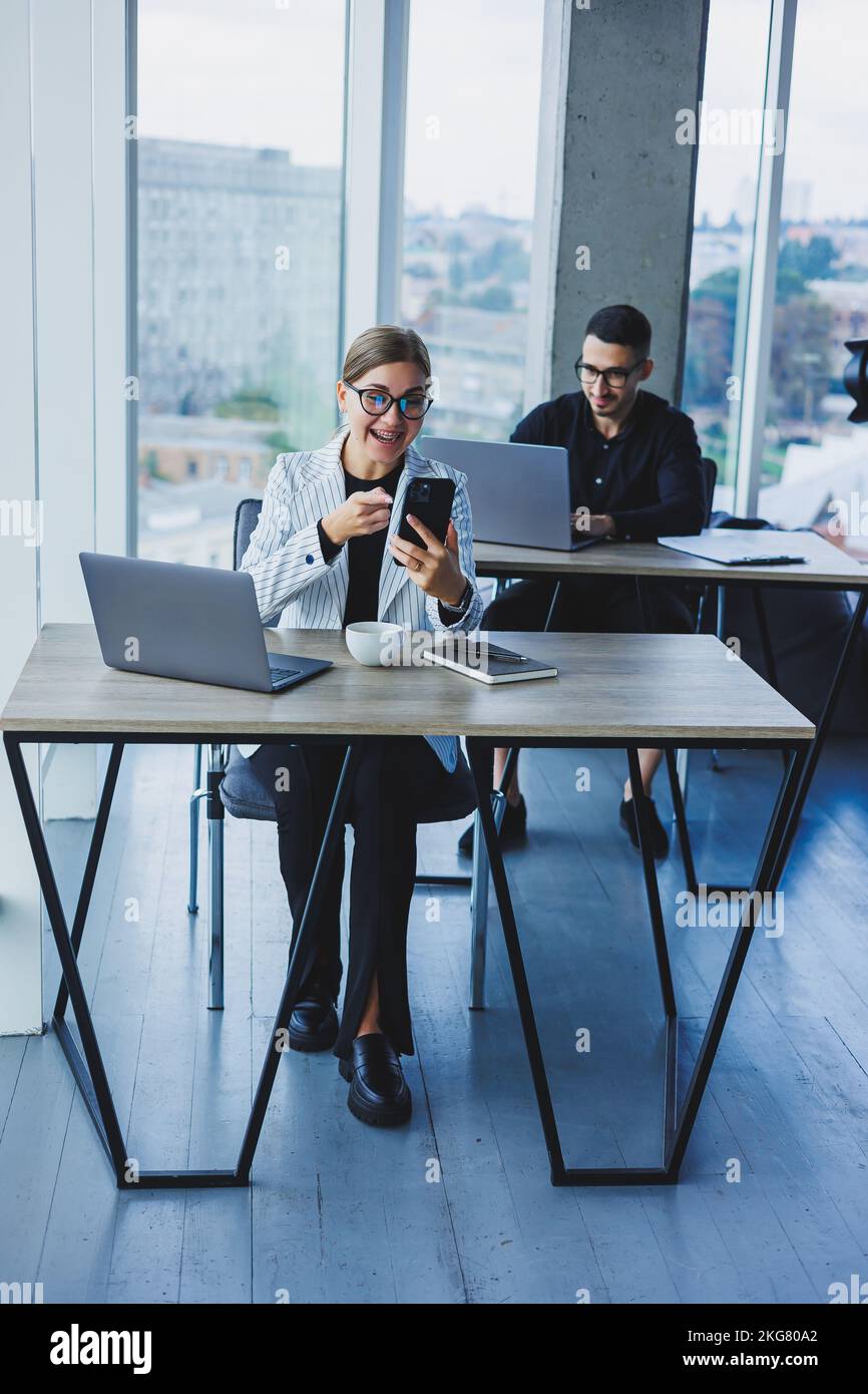 Working atmosphere in an office with large windows. A female manager is ...