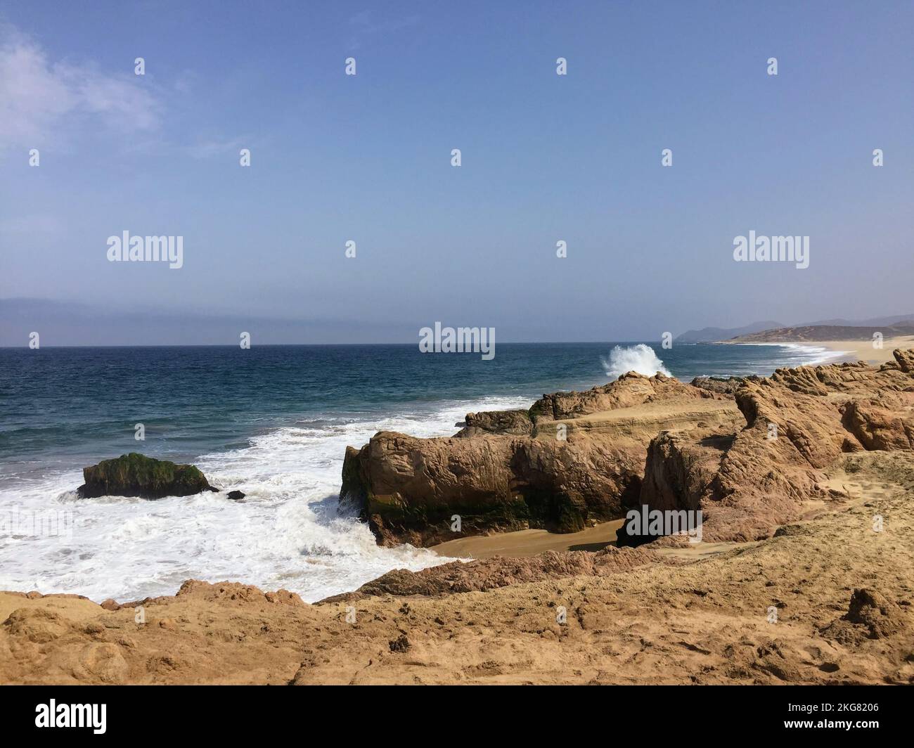 A rocky shore of the Baja California peninsula washed by the waters of ...
