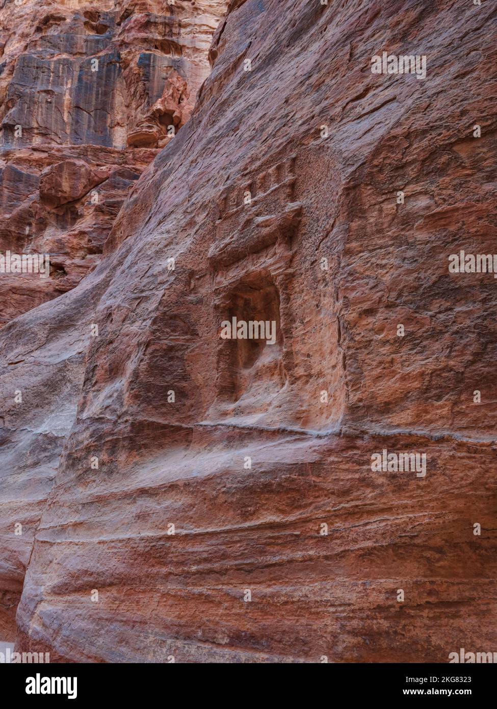 A vertical shot of a temple engraving on a rough cliff texture in Wadi ...