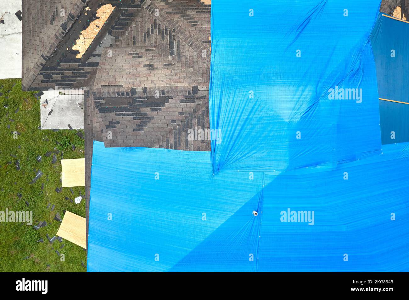 Aerial view of damaged in hurricane Ian house roof covered with blue ...