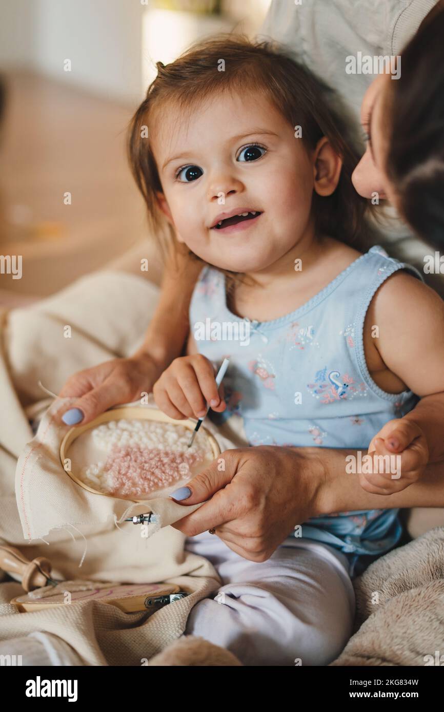Mother and baby daughter spending quality time together while learning ...