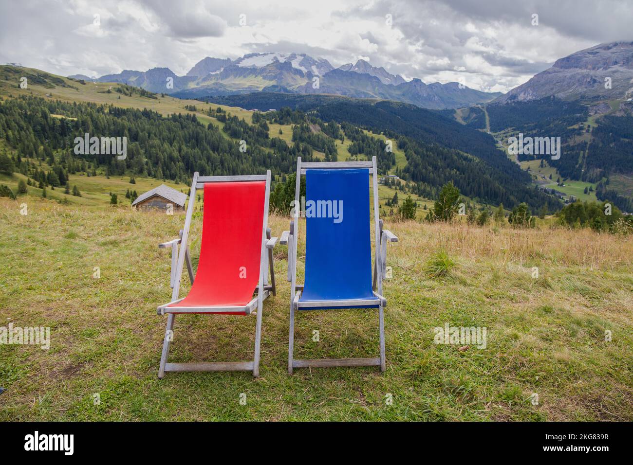 Couple of red and blue deck chairs in the Dolomitic scenery with ...