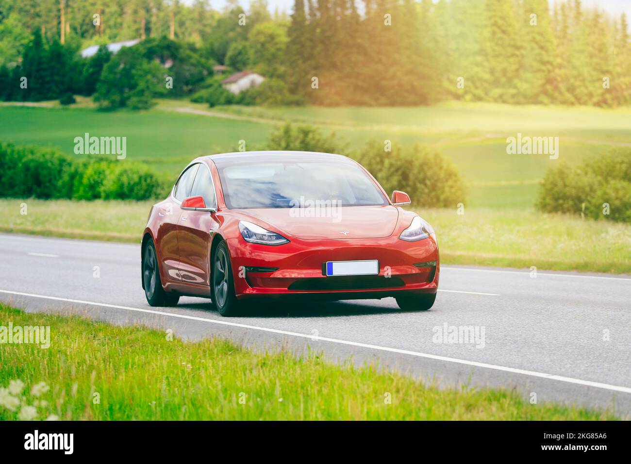 Red Tesla Model 3 sedan electric car year 2020 at speed on highway ...