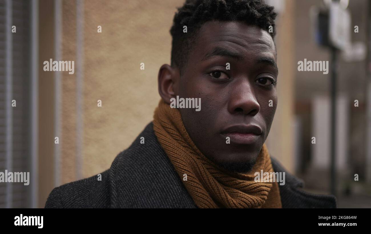 Portrait young black man staring at camera outside in urban european ...