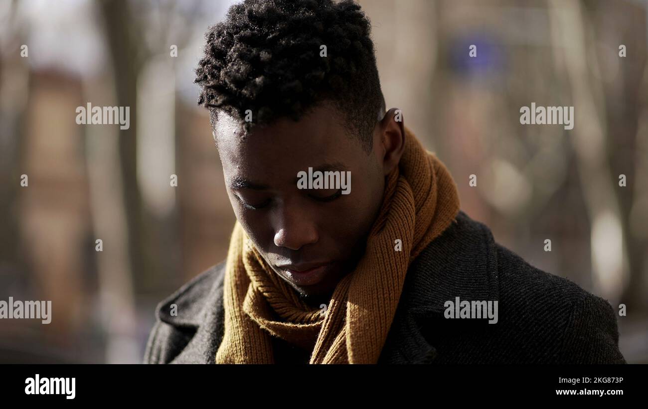 Pensive Young black African man walking outside in city Stock Photo - Alamy