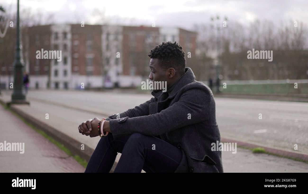 Pensive worried black African man feeling anxious and concerned sitting ...