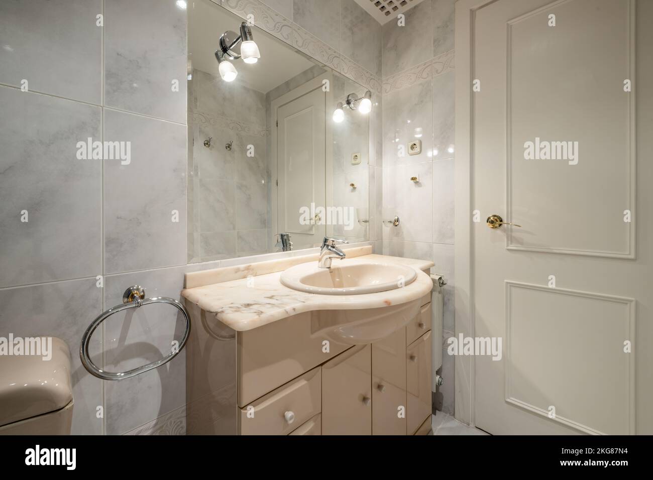Classic bathroom with cream sanitary ware, beveled mirror embedded in ...
