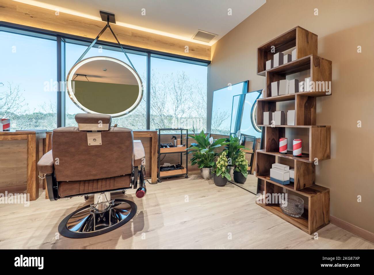 Corner of a beauty salon with a brown hairdressing chair and a circular ...