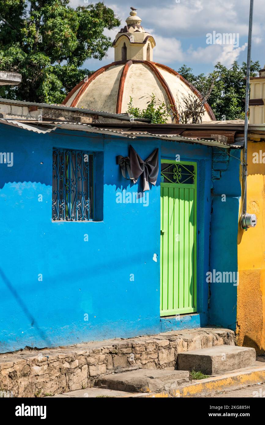 A colorfully painted blue house with a yellow door in Zaachila, Mexico ...