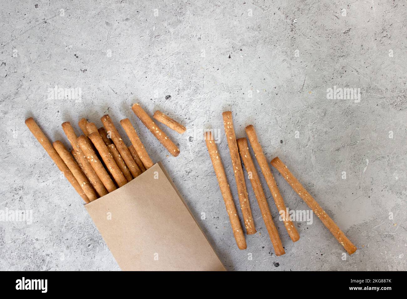 Bread sticks, with sesame seeds and whole grain flour on grey ...