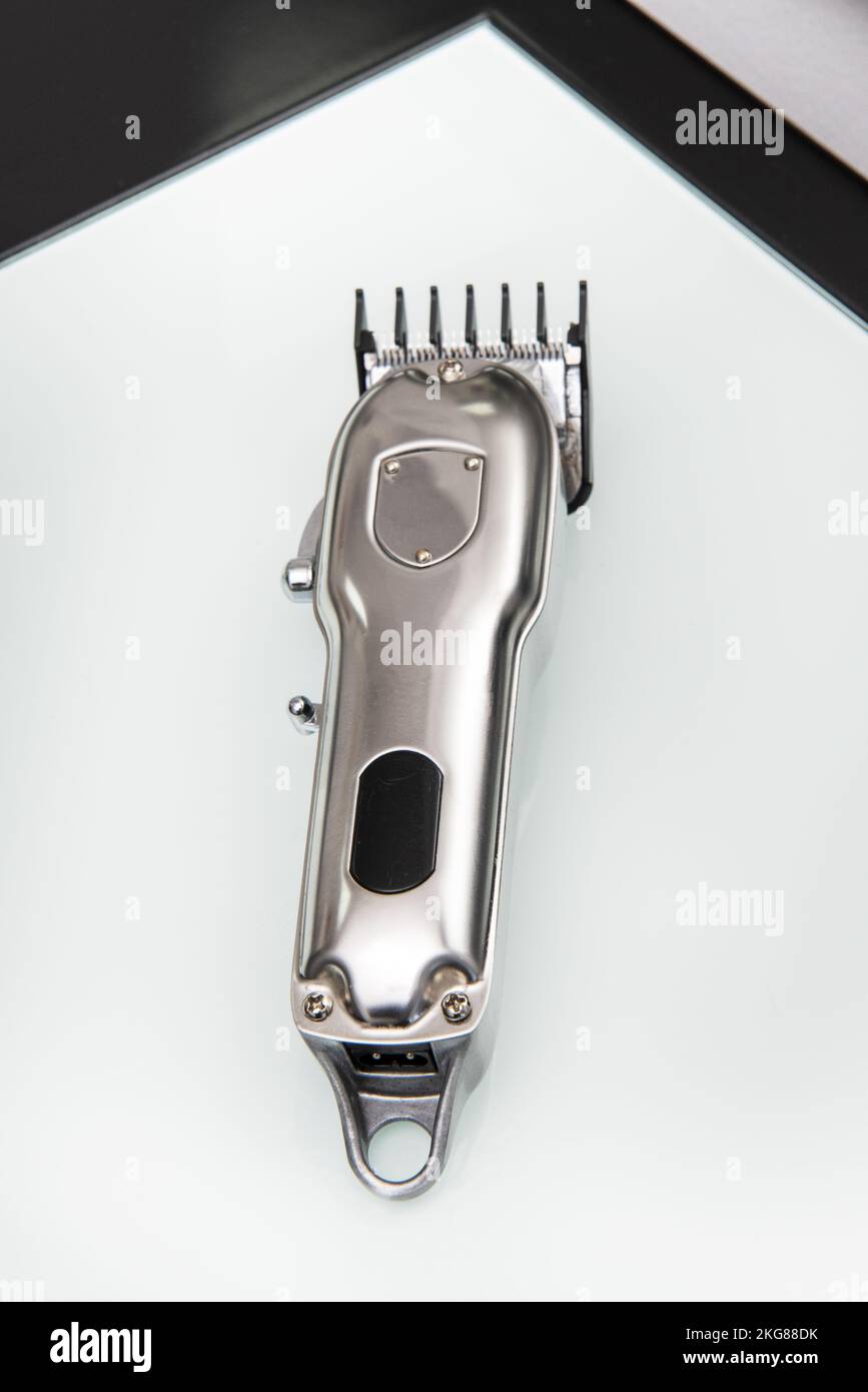 Metal hair clippers for men's barbershop on a smooth white surface ...