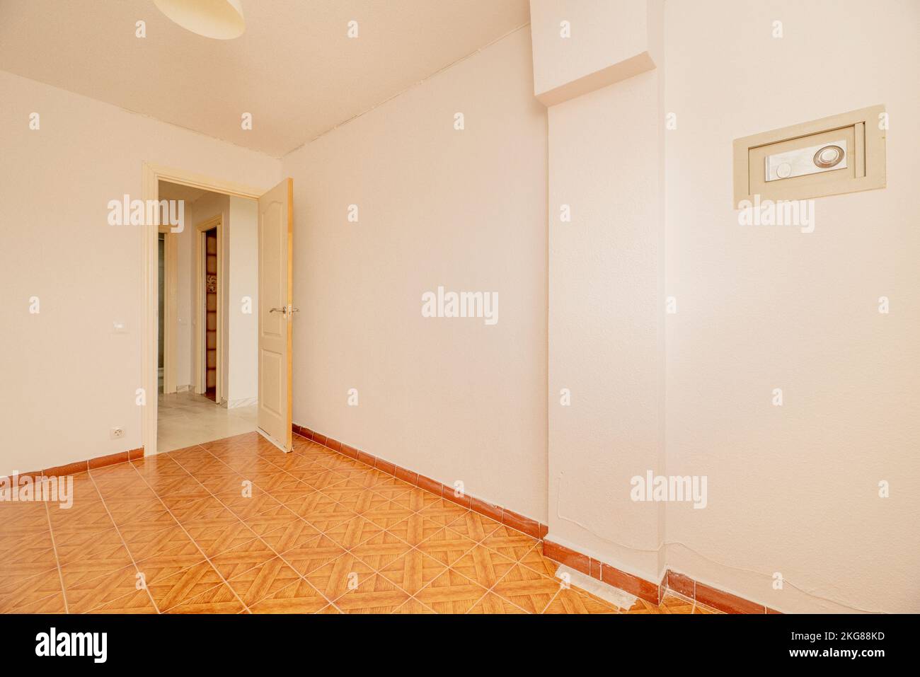 Empty room with a patterned orange vintage stoneware floor and a small ...