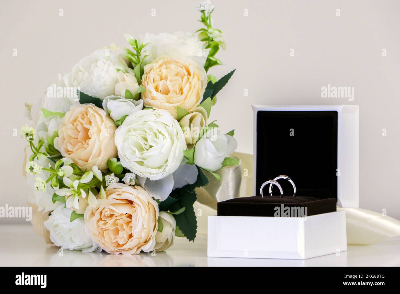 A pair of beautiful shiny wedding rings displayed in ring box besides ...