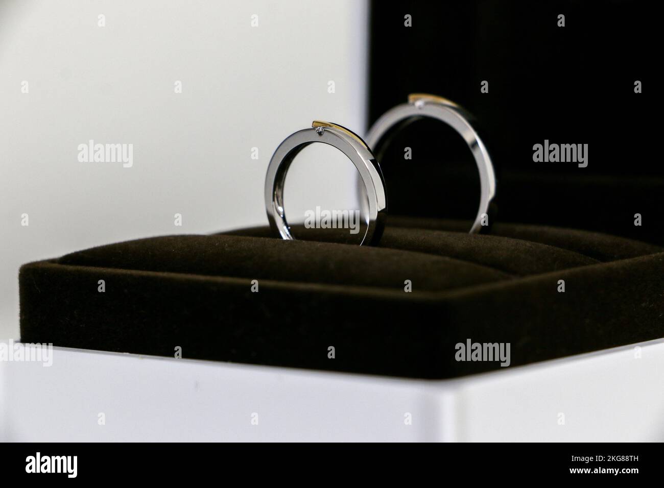 Close up of a pair of his and hers wedding rings sparkling in open ring ...