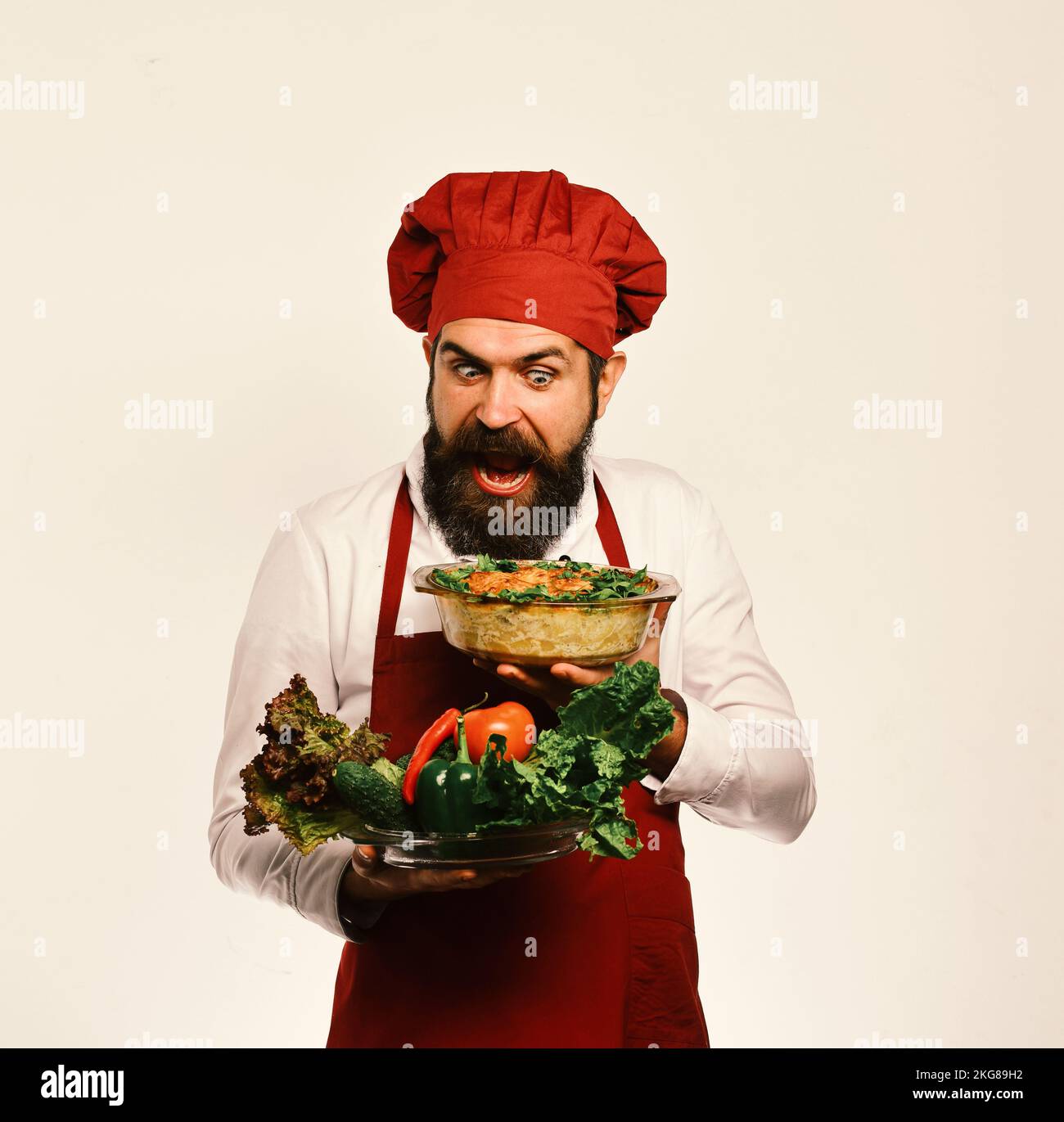 Chef holds bowl with potato casserole and vegetables Stock Photo - Alamy