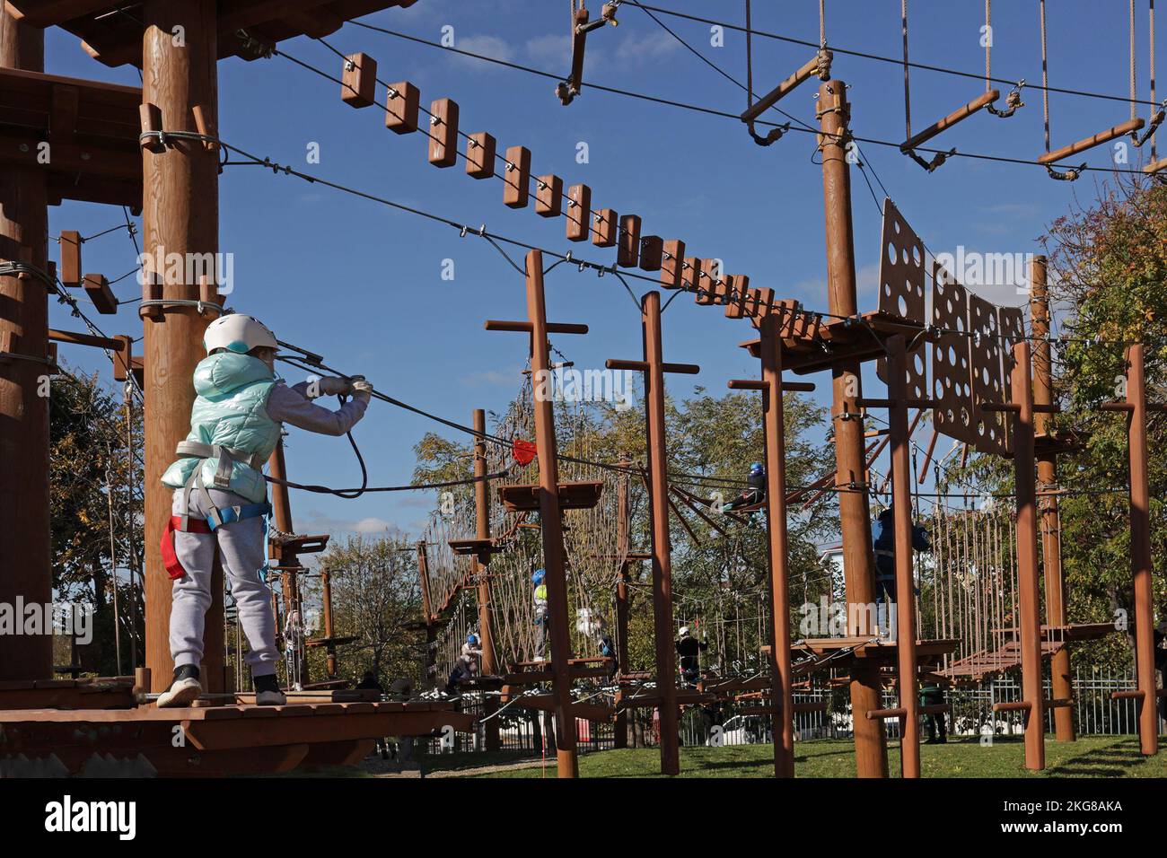 Adventure park obstacle course. Teenage girl on a difficult obstacle ...