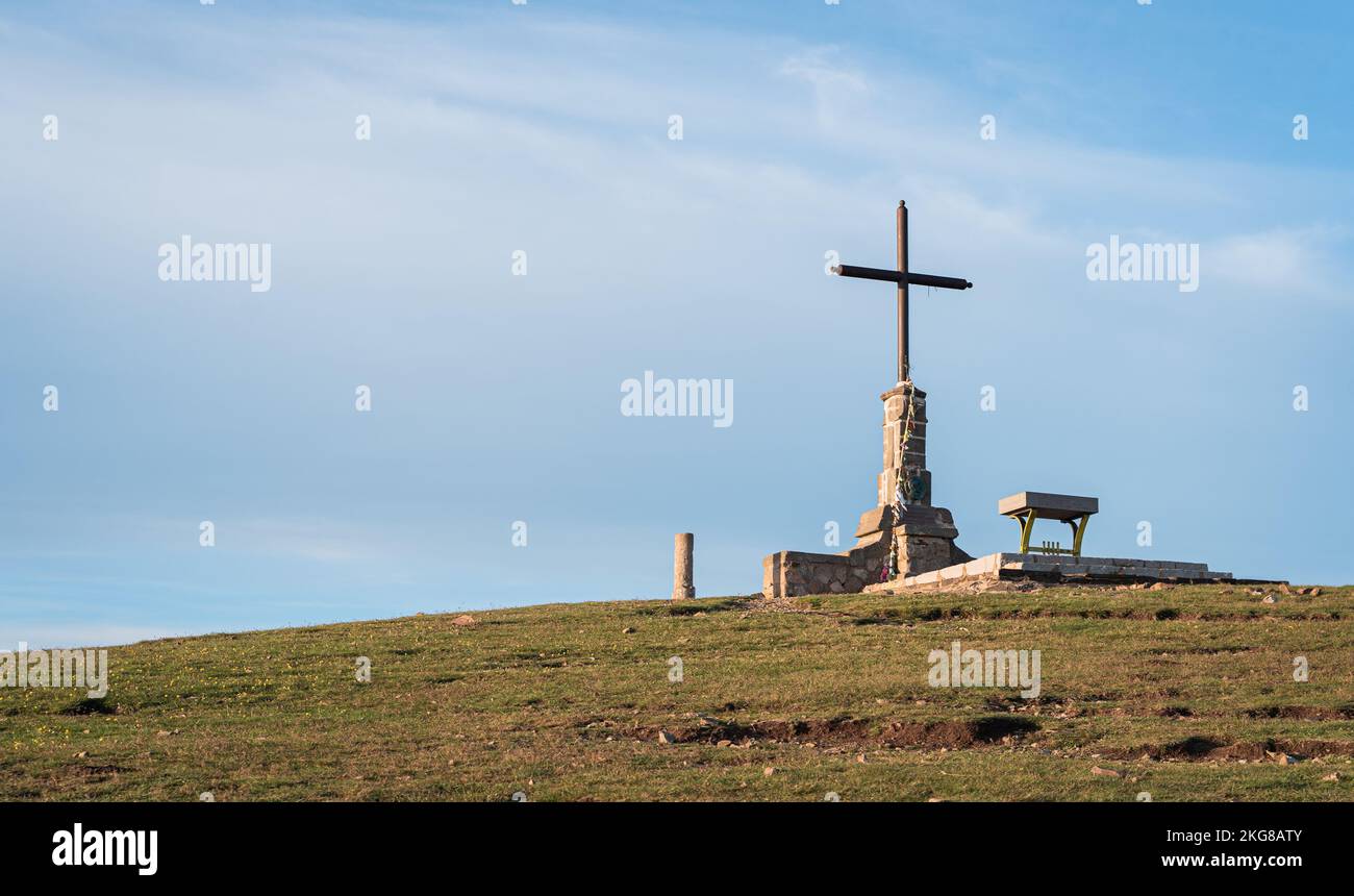 A large metal cross on Matagalls peak on blue cloudy sky background in ...