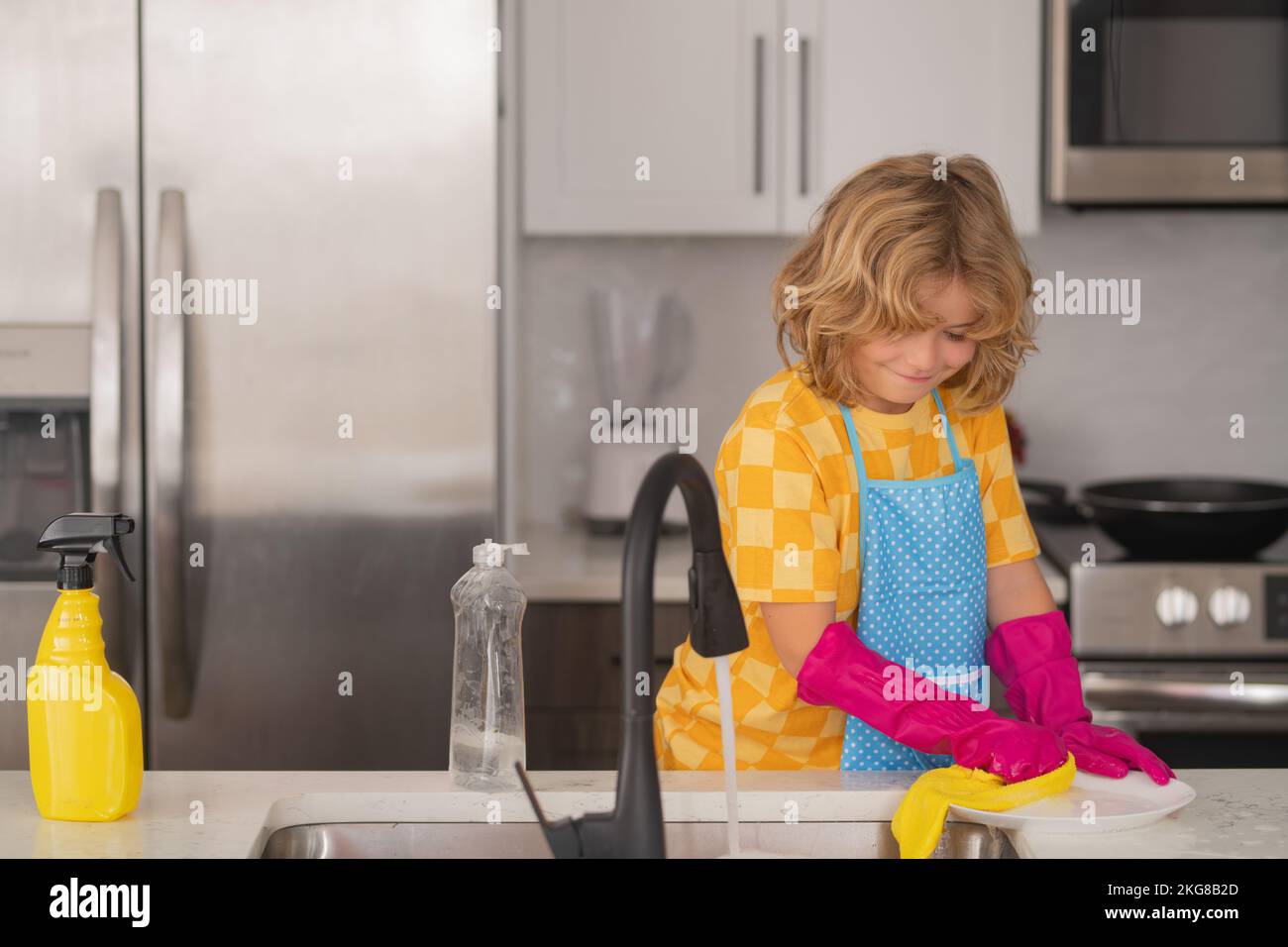 Little housekeeper. Child washing and wiping dishes in kitchen ...