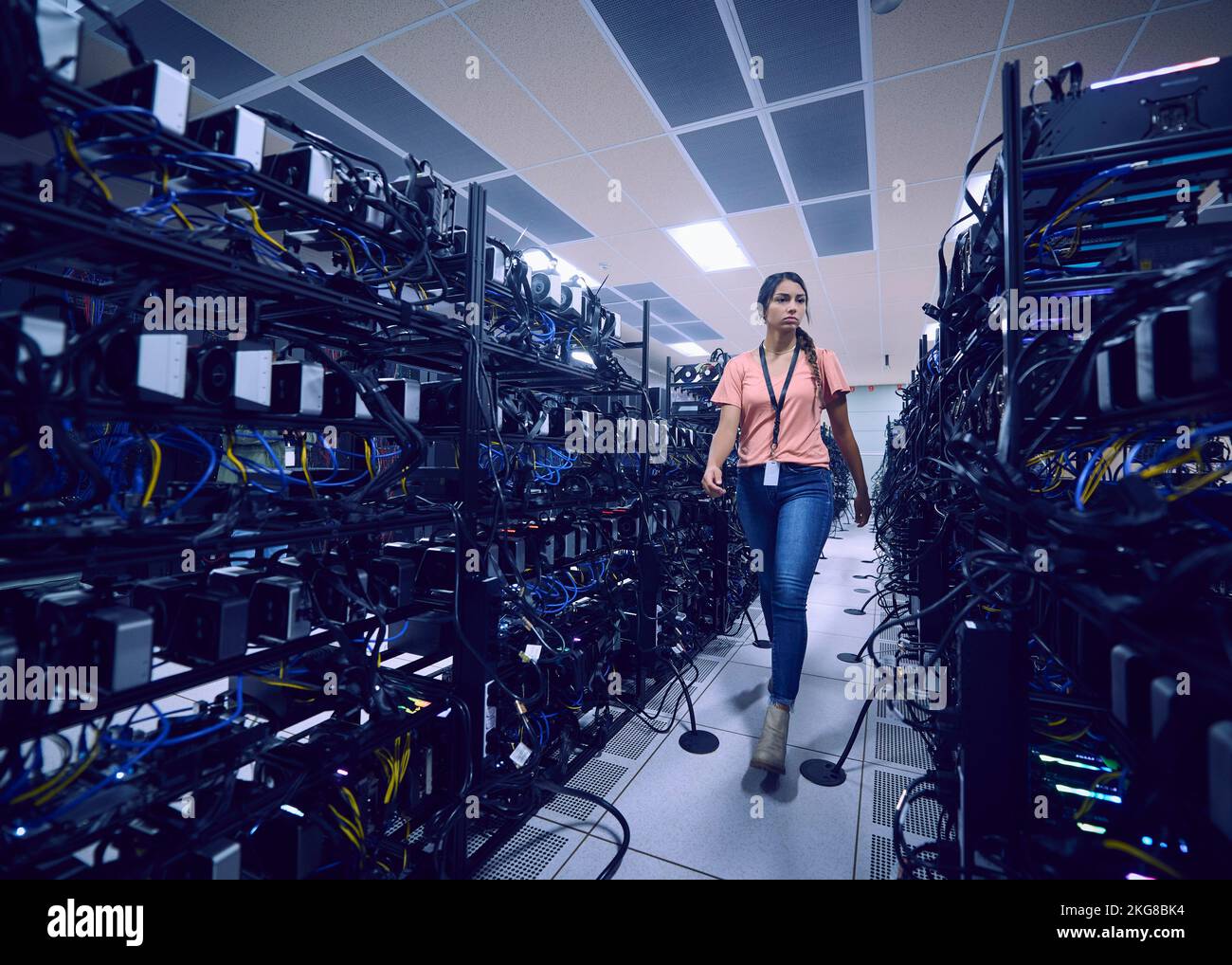 Female technician walking in server room Stock Photo - Alamy