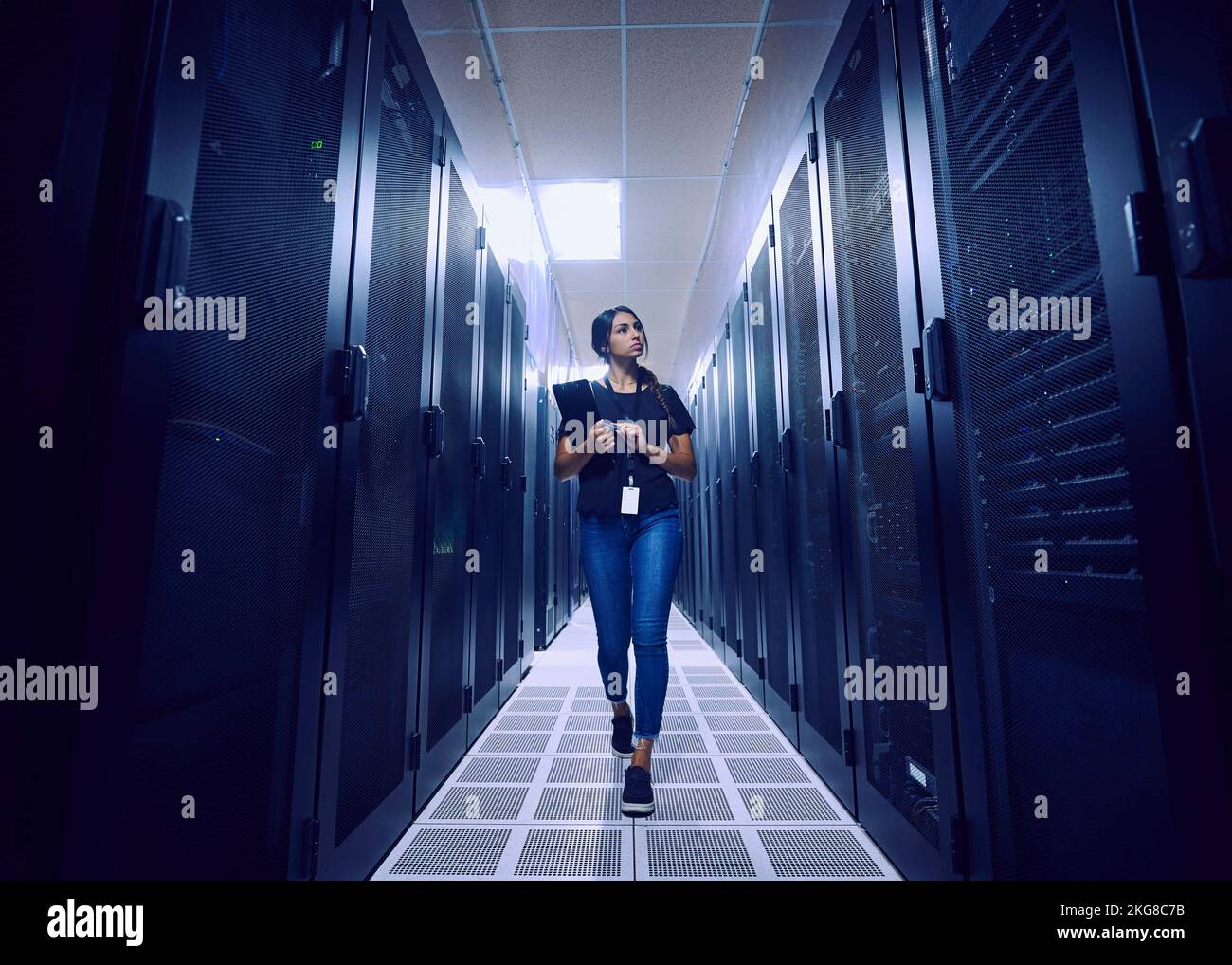 Female technician walking in server room Stock Photo - Alamy