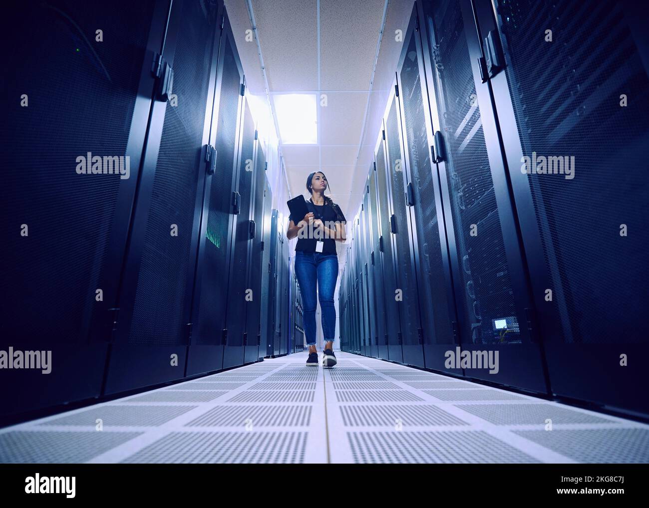 Female technician walking in server room Stock Photo - Alamy