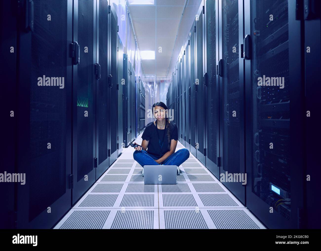Portrait of female technician sitting on floor in server room Stock ...