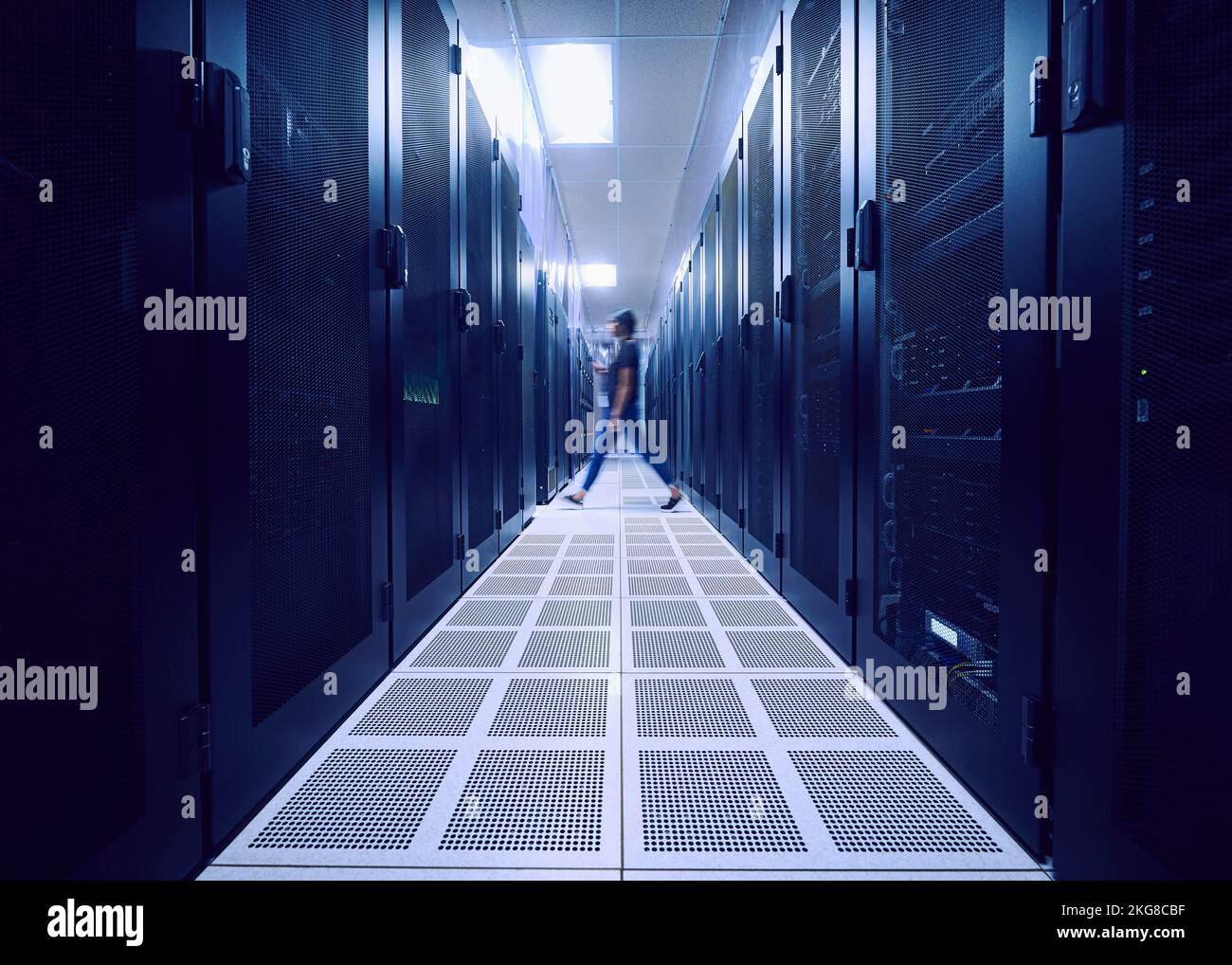 Female technician walking in server room Stock Photo - Alamy