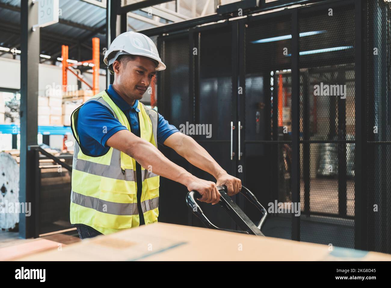 Asian male warehouse staff worker manage factory products goods and ...