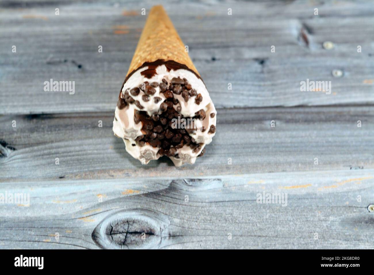 Ice cream vanilla cone with topping of chocolate chips pieces in a ...