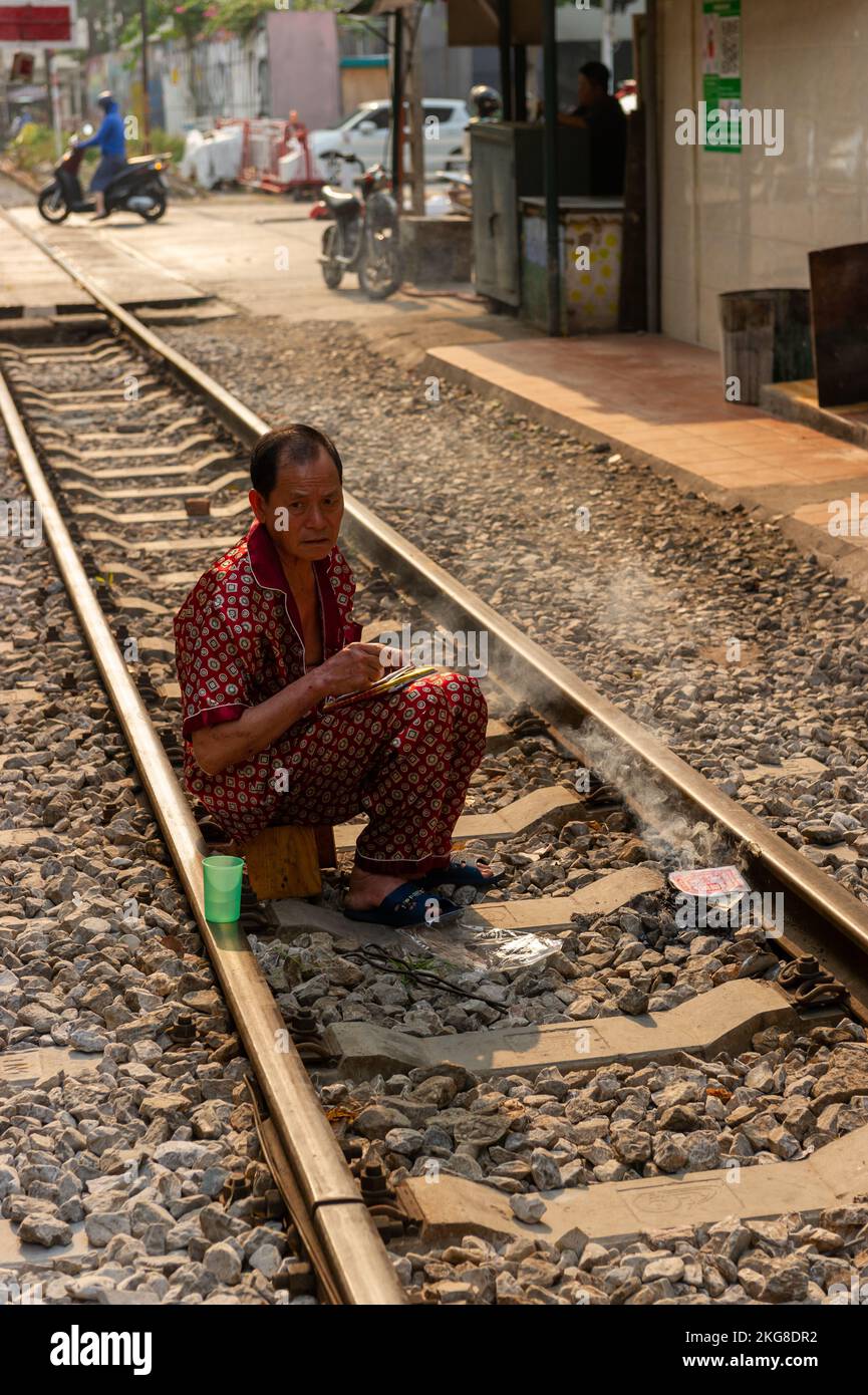 Elderly Vietnamese man burning old lottery tickets on Train Street ...
