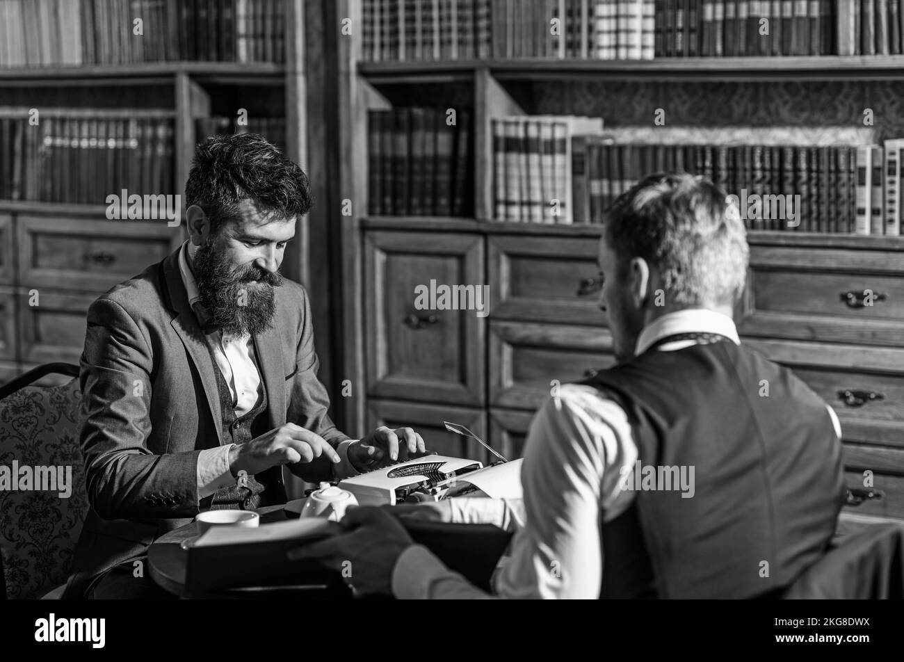 Man in suit or journalist with friend in library Stock Photo - Alamy