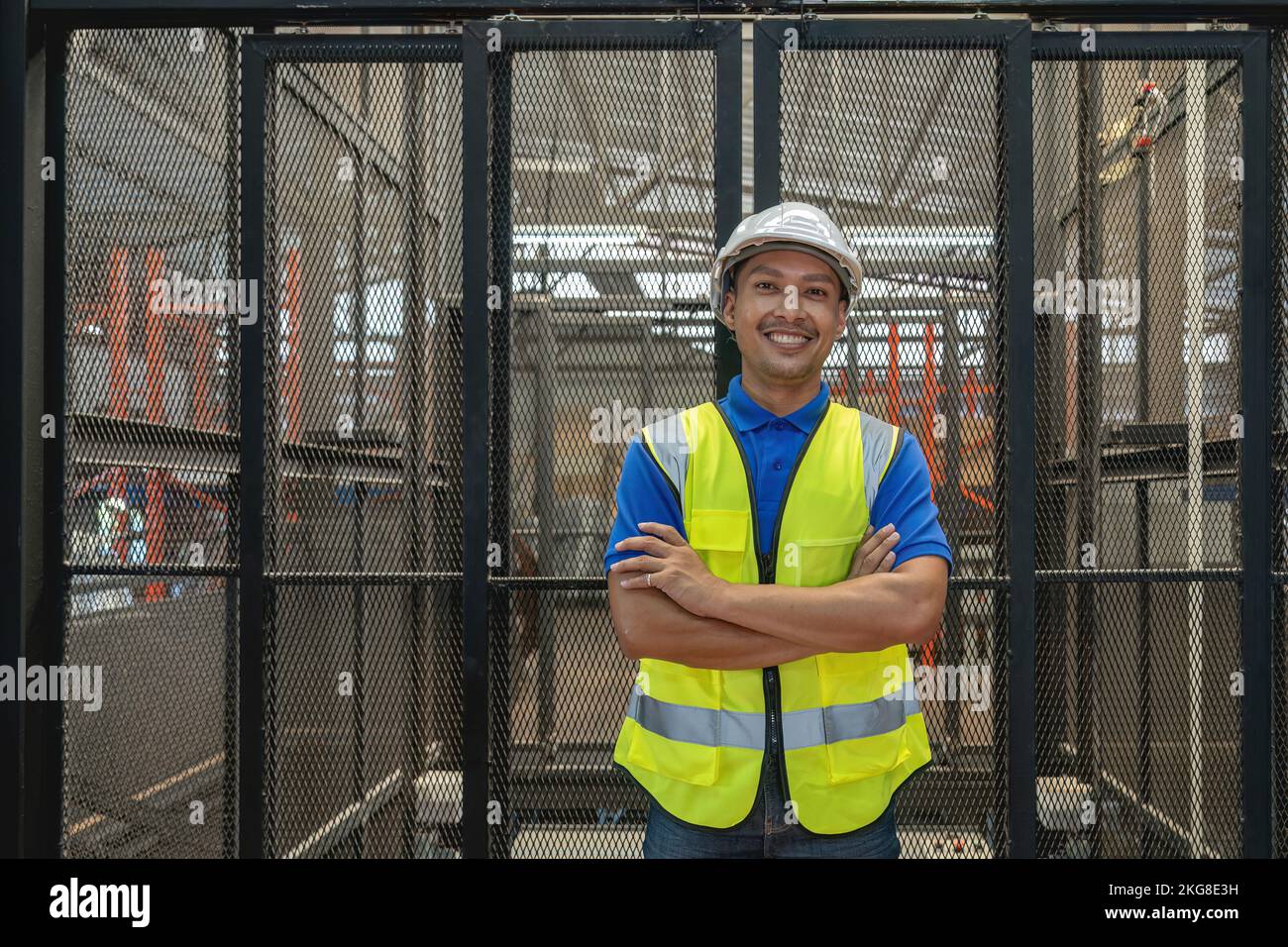 Smiling portrait of a male supervisor standing in warehouse with his ...