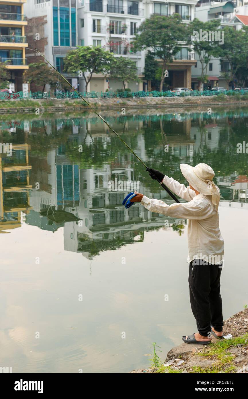 An elderly lady fishing for her fish dinner in the Hồ Tây Lake, Hanoi ...