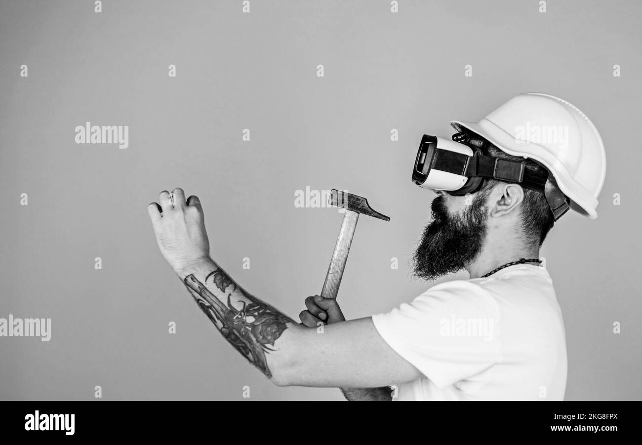 Builder and renovation concept. Man with beard in VR glasses holds ...