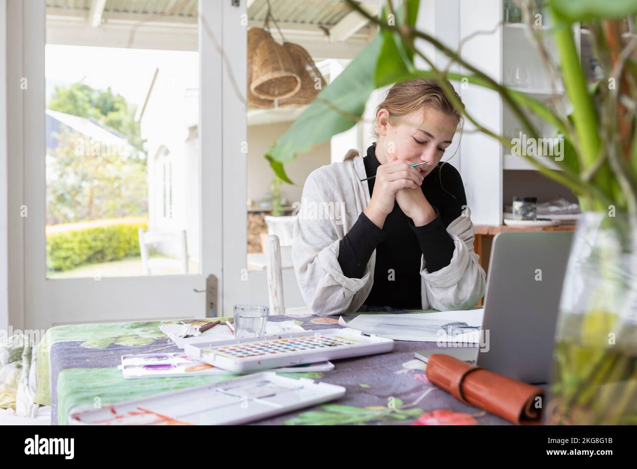 Teenage girl (16-17) artist working in art studio doing a watercolor ...