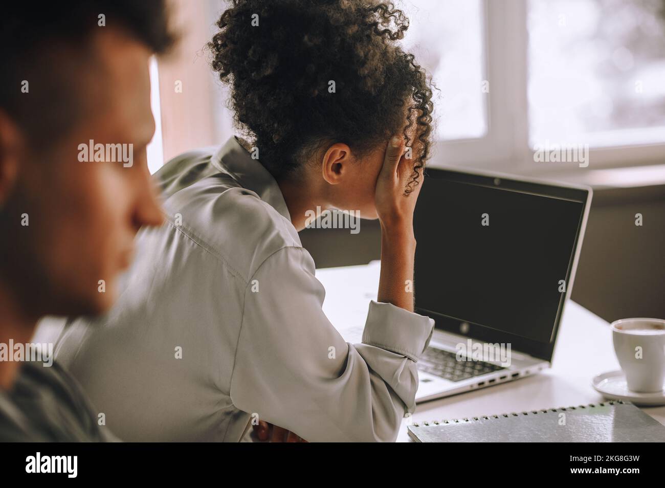 Tired female employee sitting before the laptop Stock Photo - Alamy