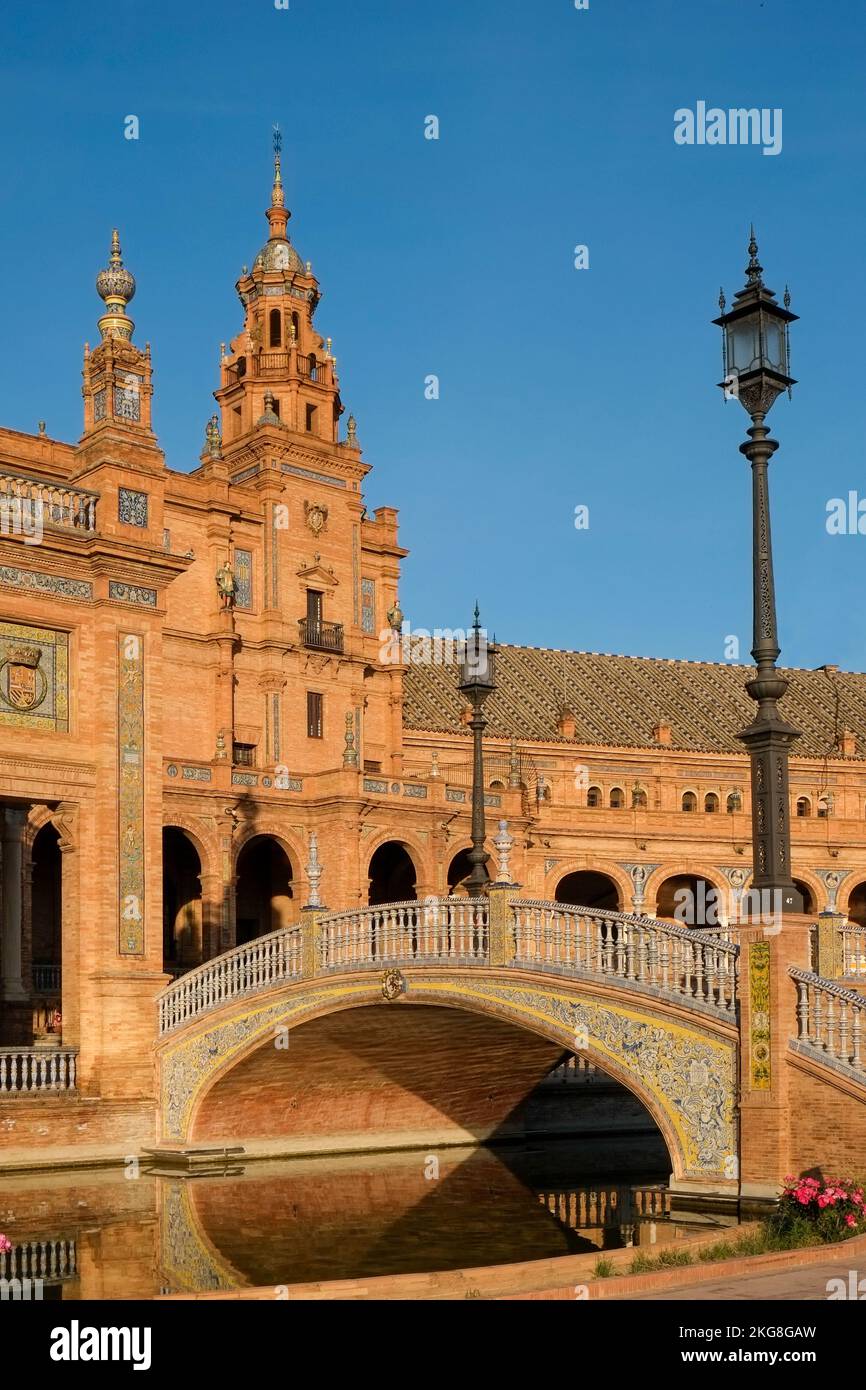 Spain, Seville, Arch bridge over canal and brick church in background ...