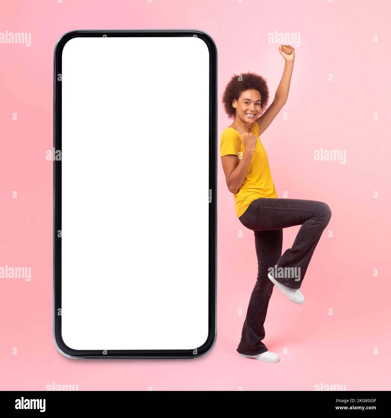 Cheerful young african american curly female rejoices, makes victory ...