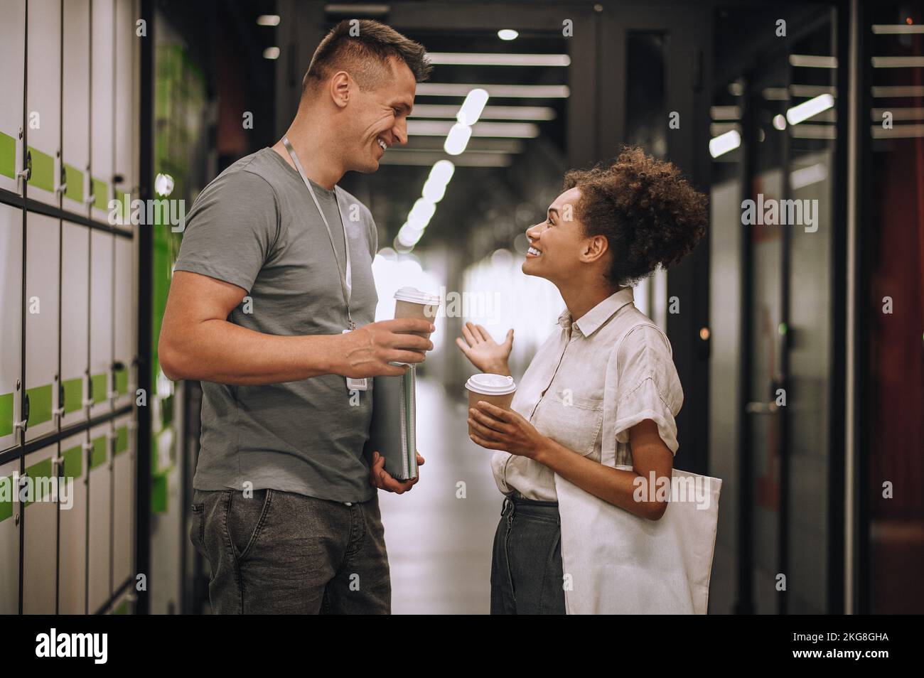 Cheerful young coworkers having a conversation during the coffee break ...