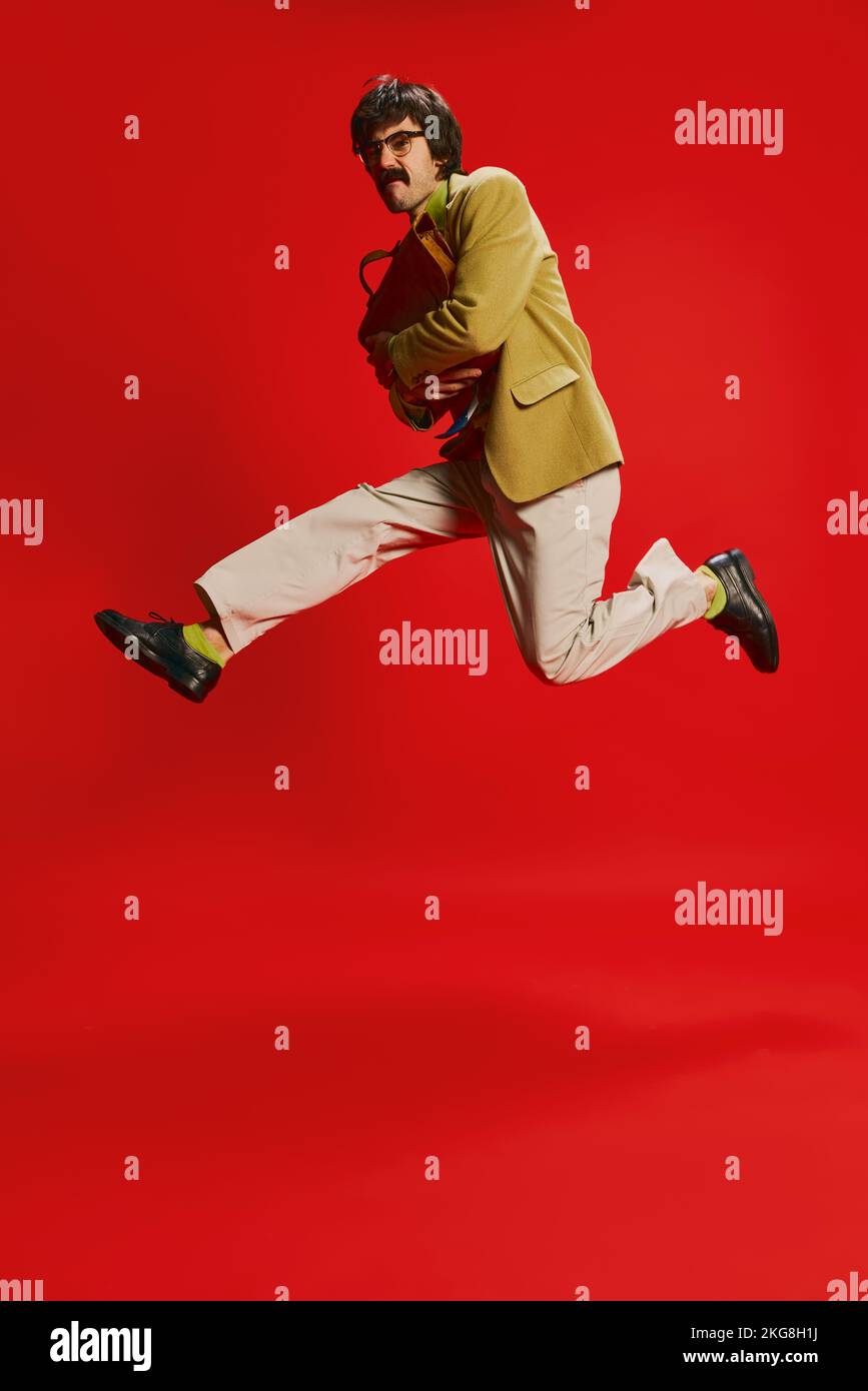 Portrait of stylish man with moustache posing in vintage suit in a jump ...
