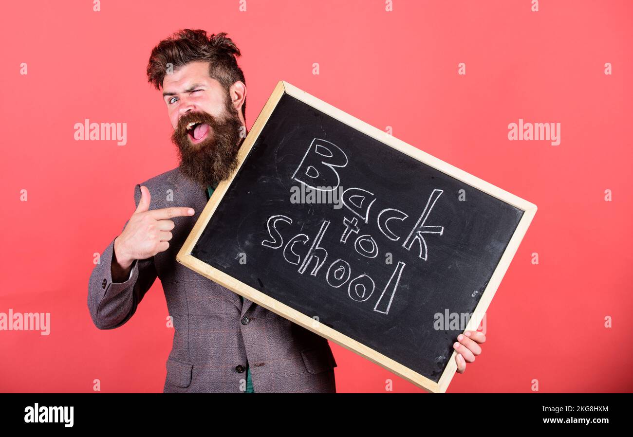 Teacher or educator welcomes students while holds chalkboard with ...